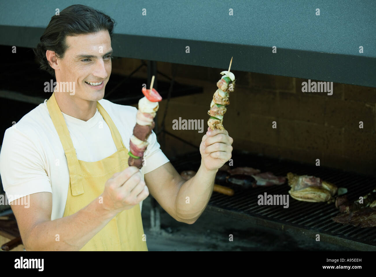 Man holding up two kebabs Stock Photo - Alamy