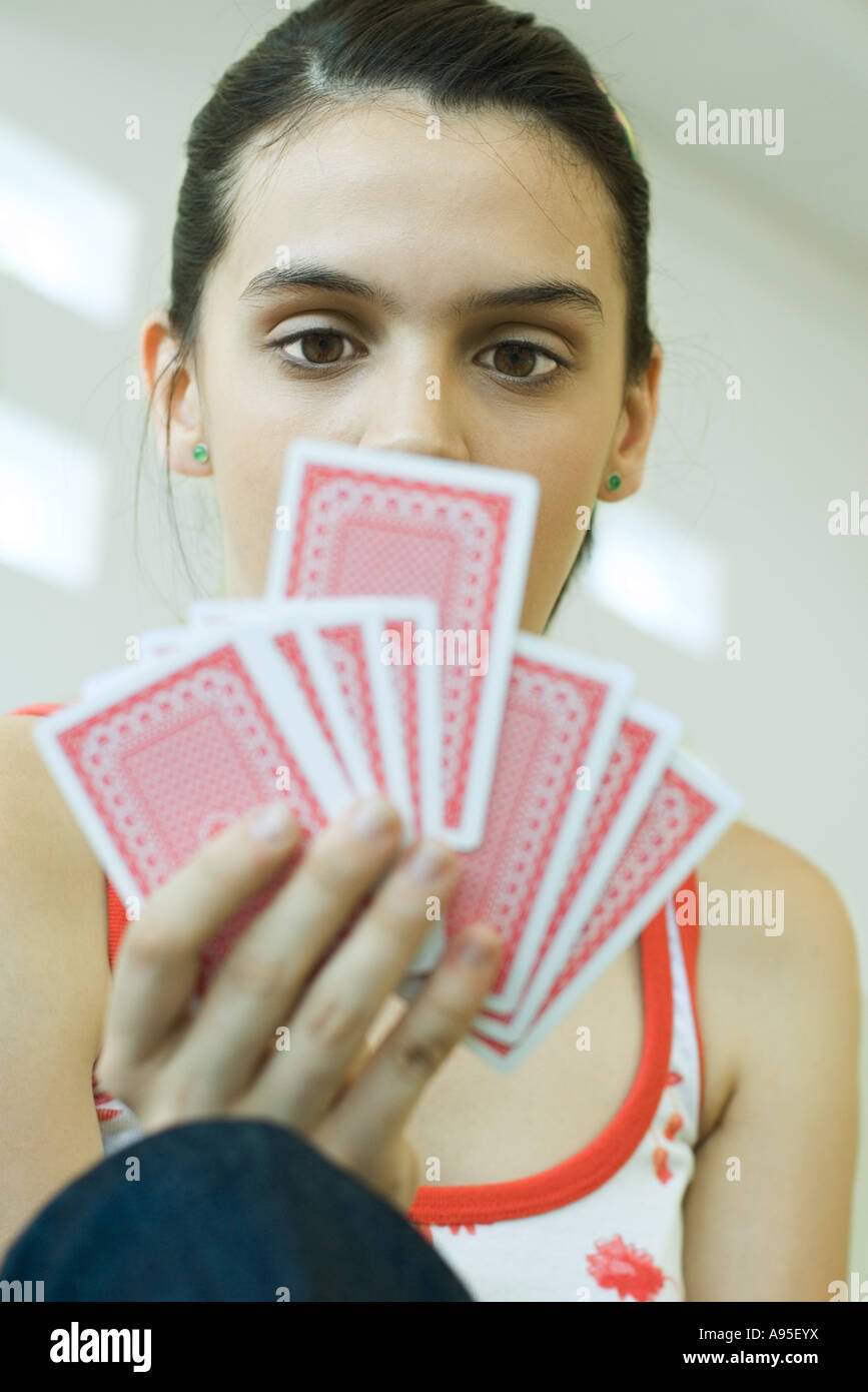 Teenage girl holding up hand of cards Stock Photo - Alamy