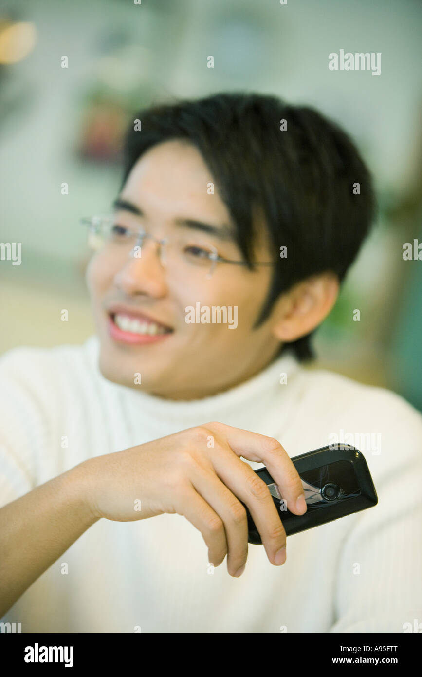 Young man holding cell phone Stock Photo - Alamy