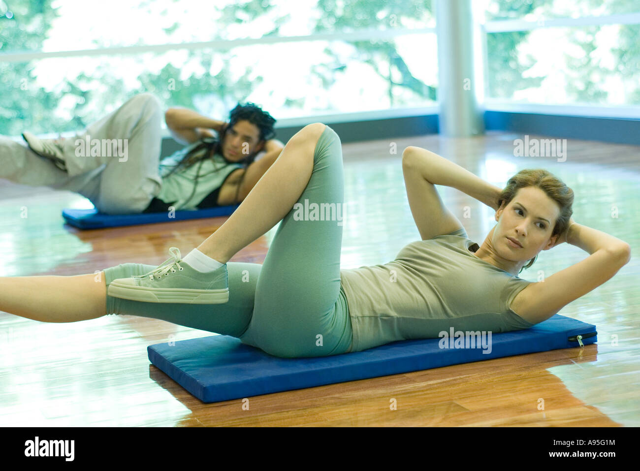 Young adults doing sit-ups in exercise class Stock Photo - Alamy
