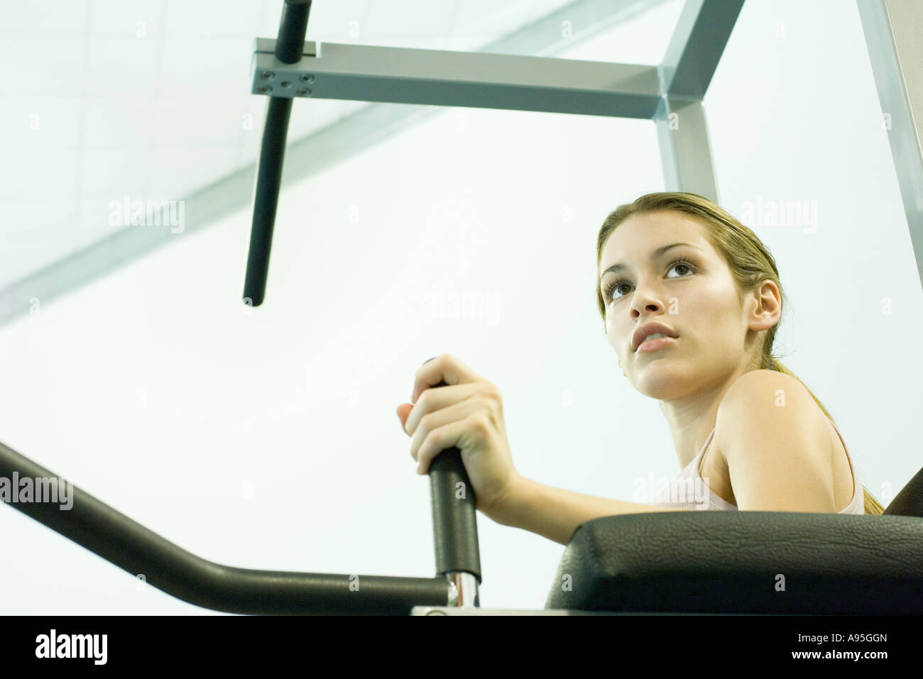 Woman using weight machine Stock Photo - Alamy