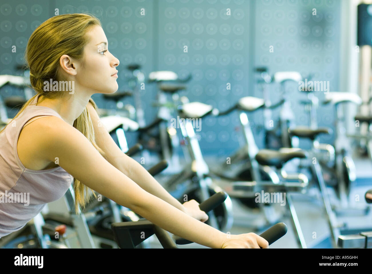 Woman sitting on stationary exercise bike Stock Photo - Alamy