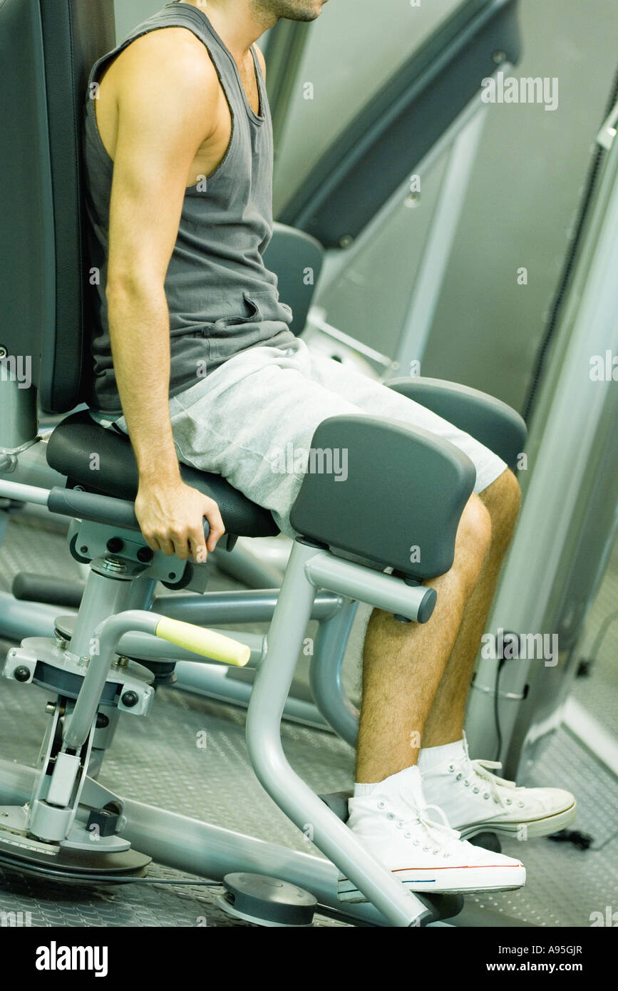 Man working out on weight machine Stock Photo - Alamy