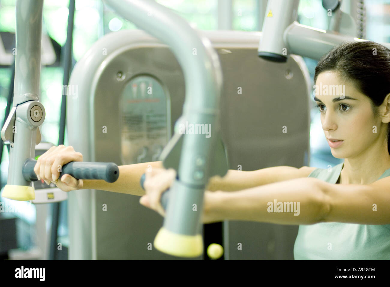 Woman working out with weight machine Stock Photo - Alamy