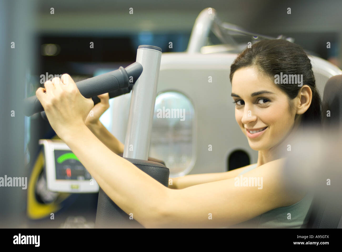 Woman working out with weight machine Stock Photo - Alamy