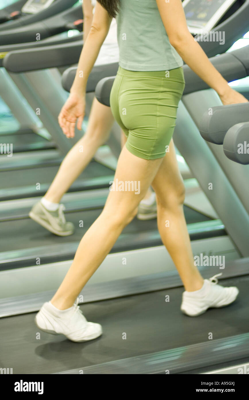 Two women walking on treadmills, chest down Stock Photo - Alamy
