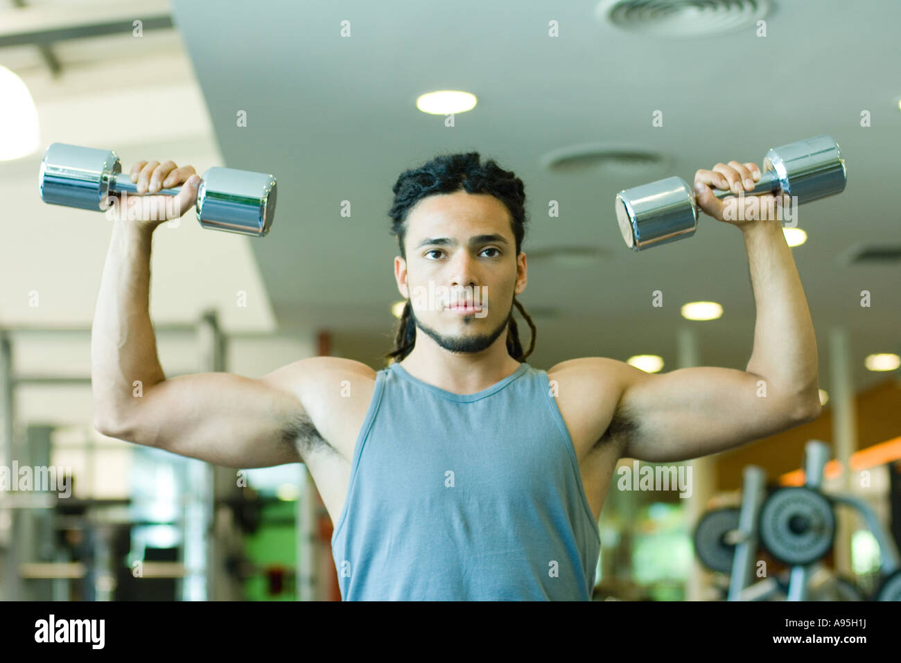 Man lifting dumbbells, waist up, front view Stock Photo - Alamy
