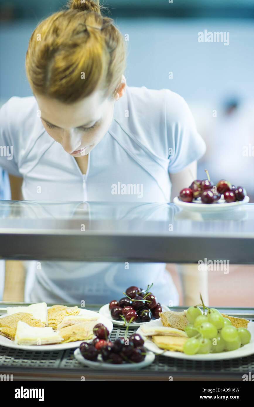 Young woman standing, choosing healthy snack in cafeteria Stock Photo ...
