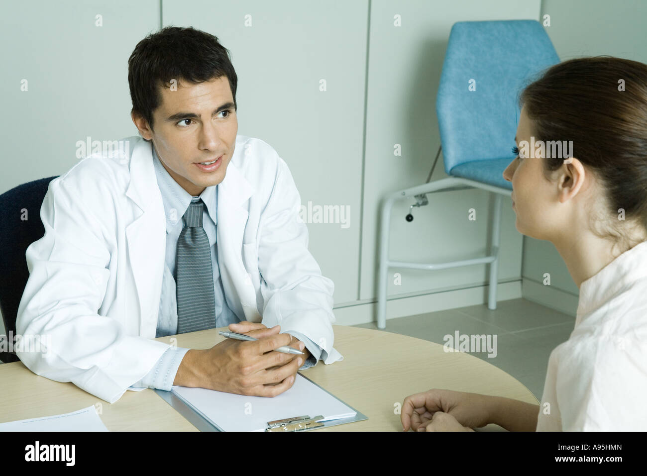 Doctor sitting across from female patient Stock Photo - Alamy
