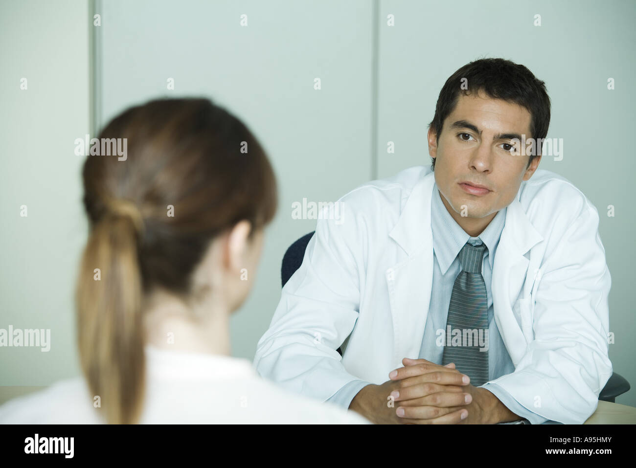 Doctor sitting across from female patient Stock Photo - Alamy