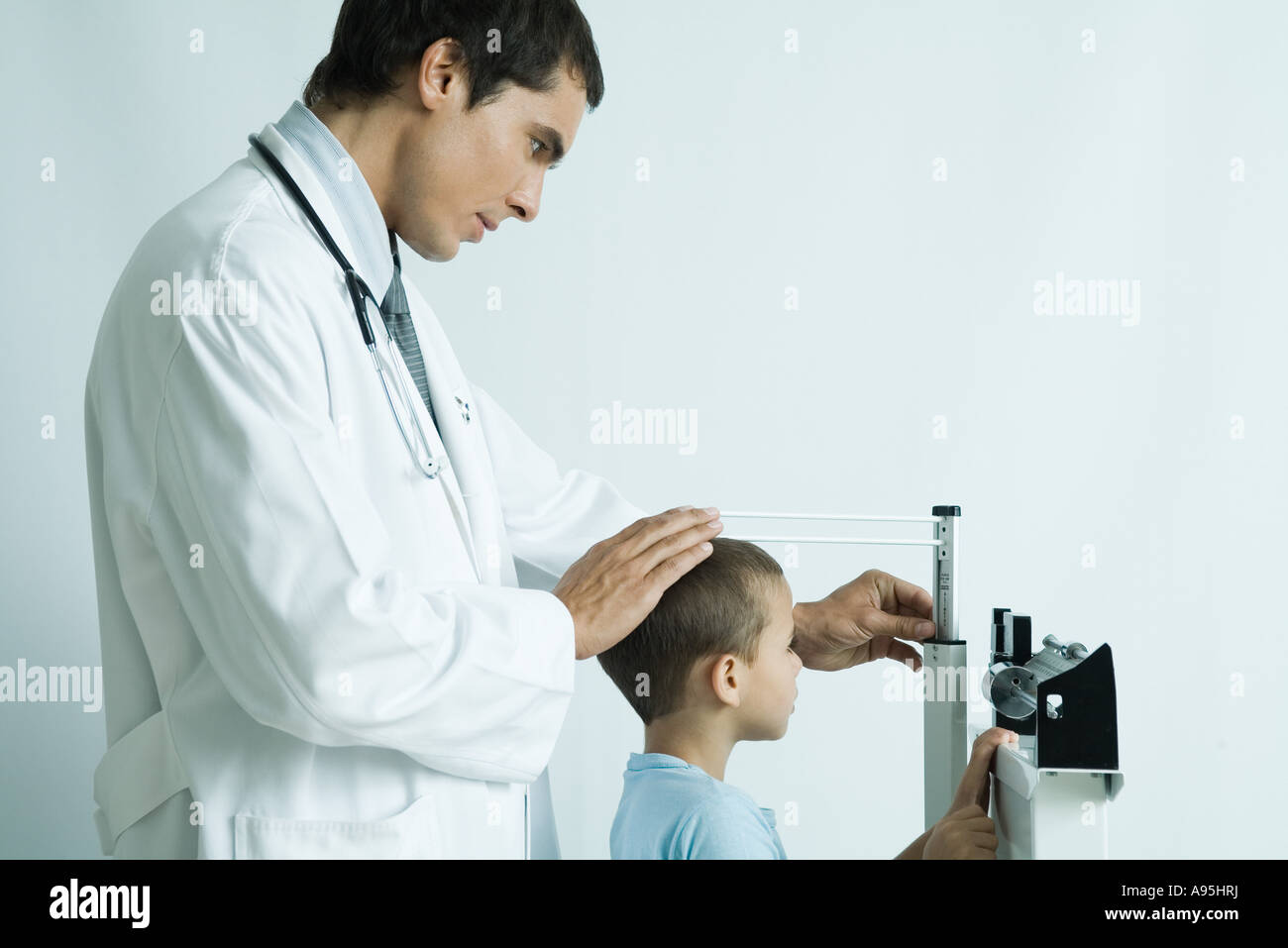 Doctor measuring boy during check-up Stock Photo - Alamy