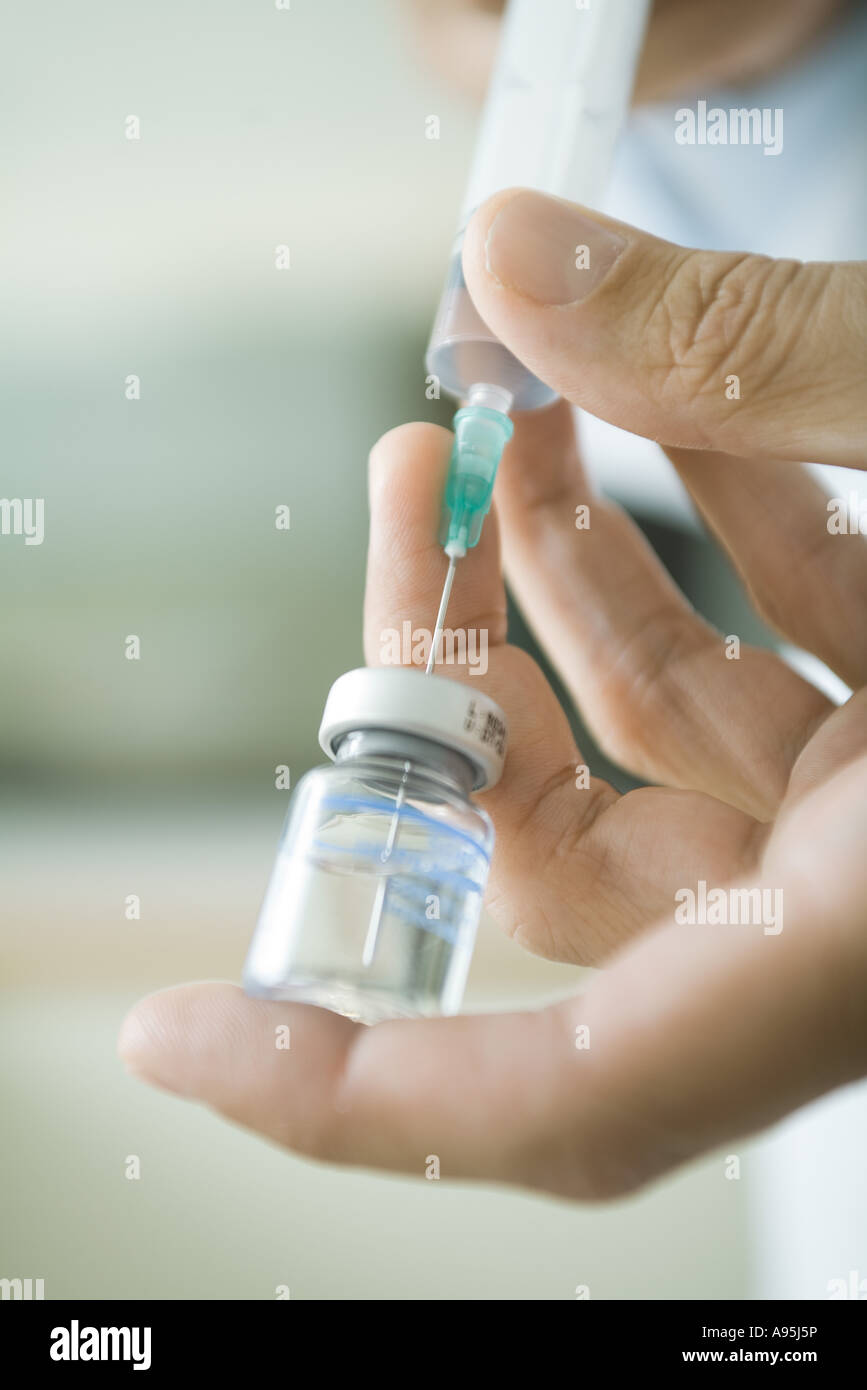 Doctor filling syringe from bottle Stock Photo - Alamy