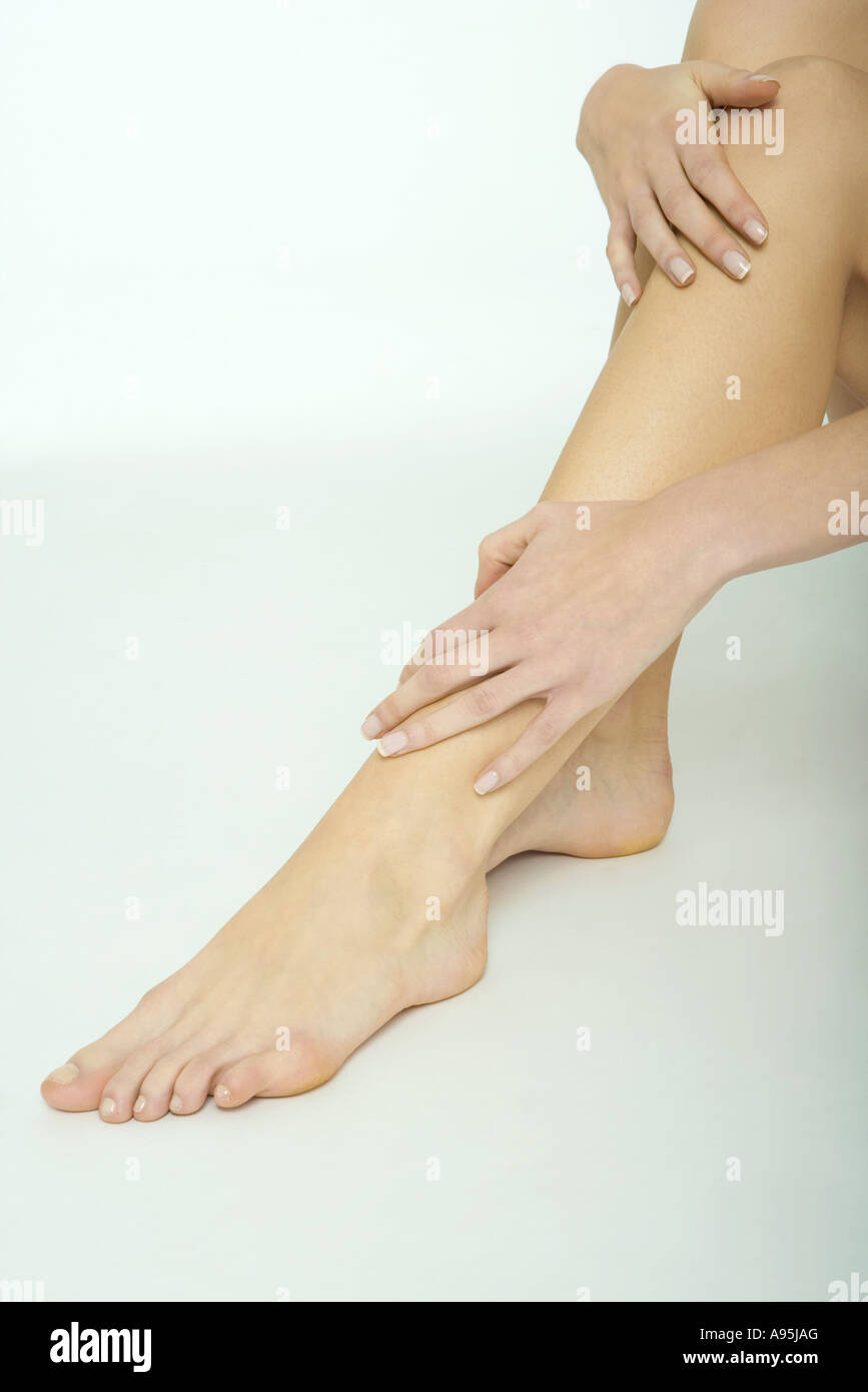 Woman touching legs, close-up, cropped view from knee down Stock Photo ...