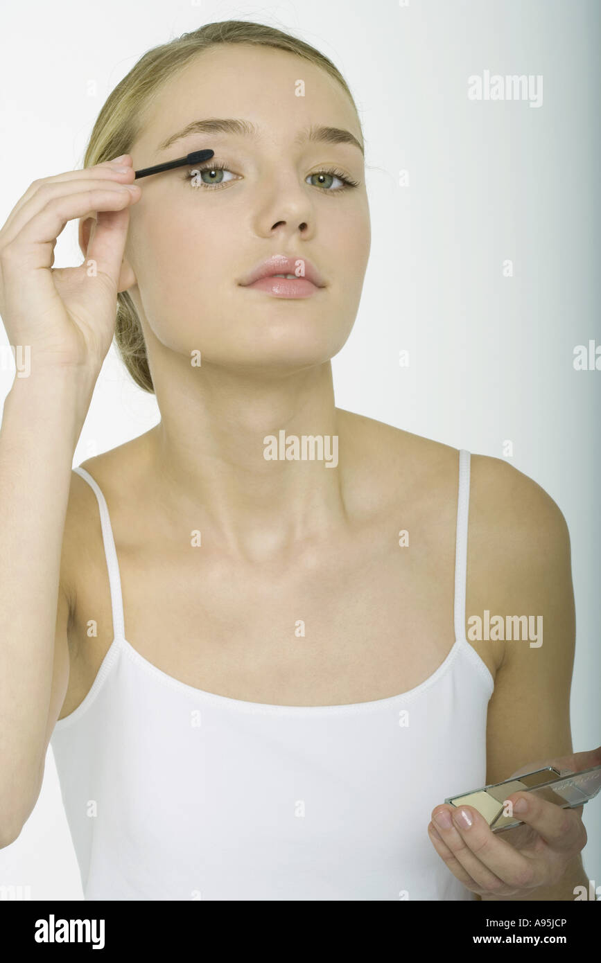 Teenage girl putting on eyeshadow Stock Photo - Alamy