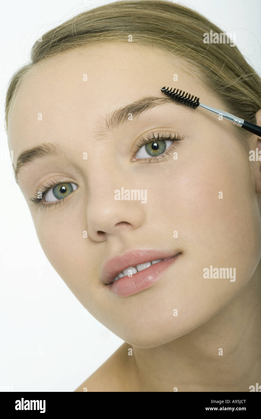 Teenage girl brushing eyebrows Stock Photo - Alamy