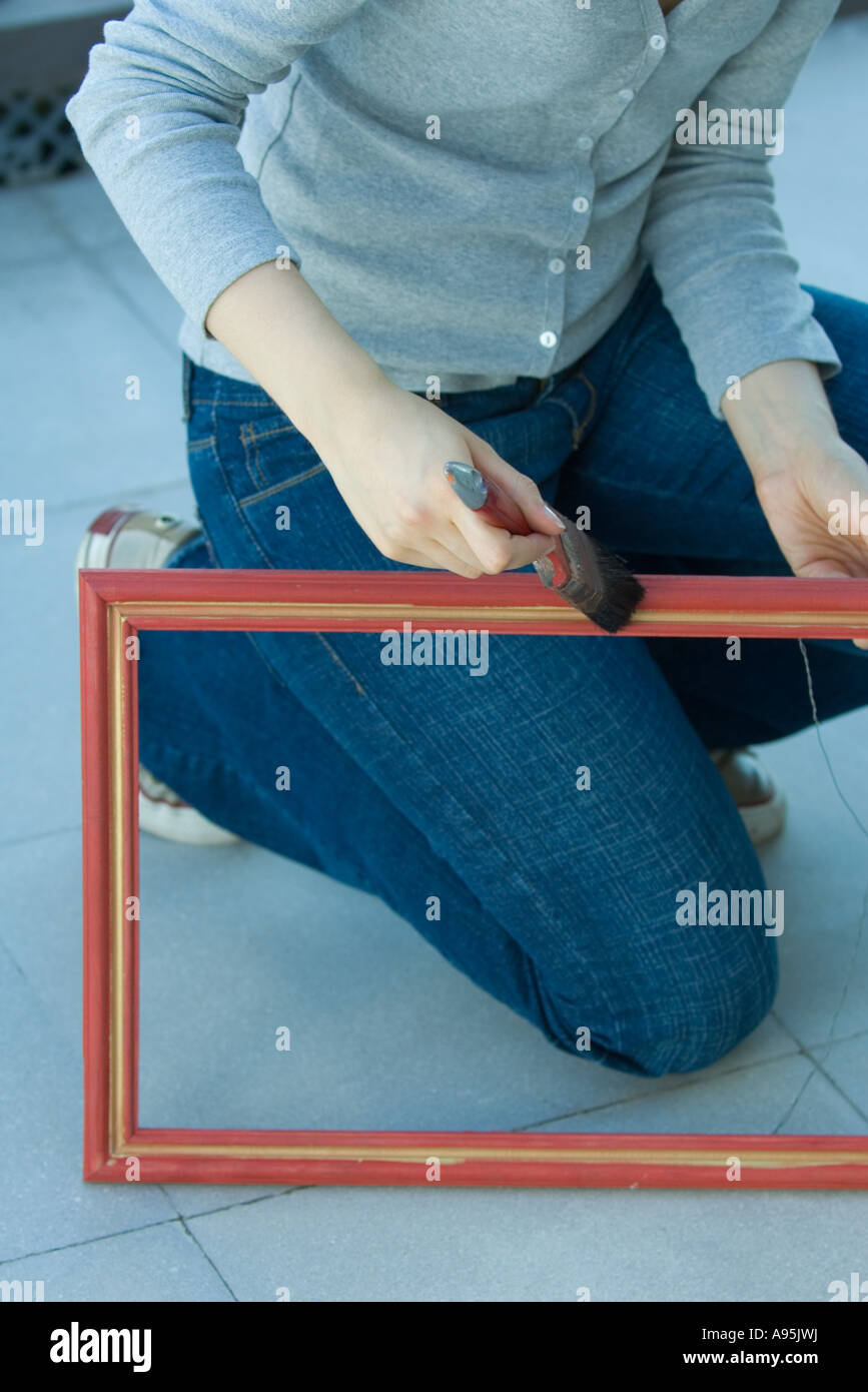 Young woman painting picture frame Stock Photo - Alamy