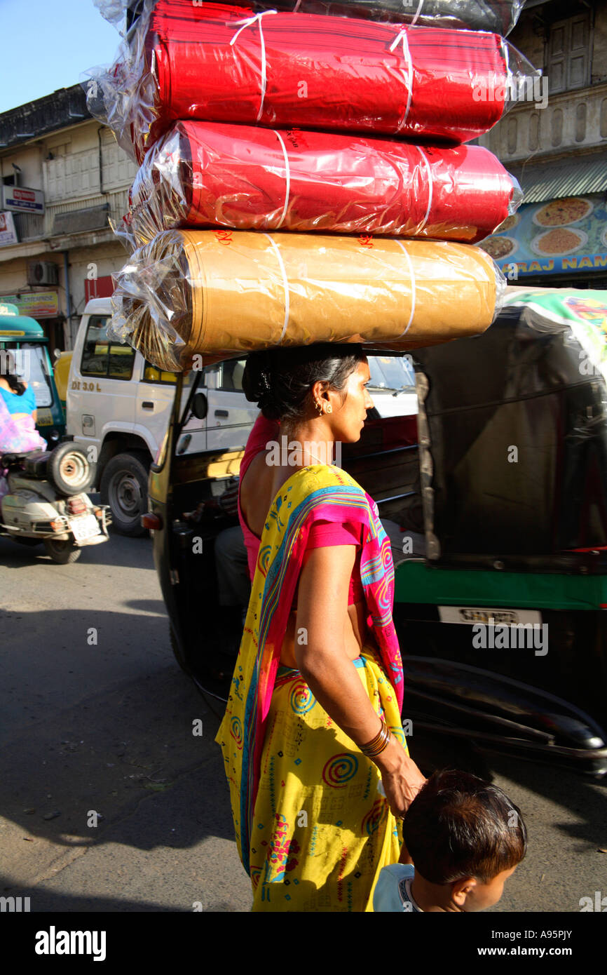 Female Indian porter carrying heavy load on head, Ahmedabad, Gujarat ...