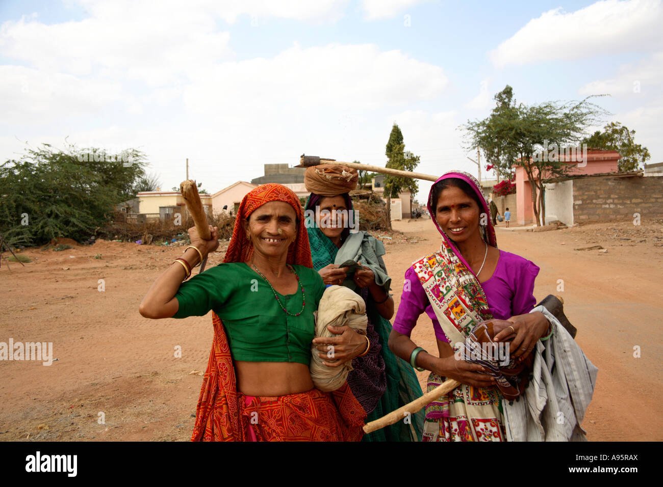 Three female Indian woodcutters posing for camera outside Hiralaxmi ...