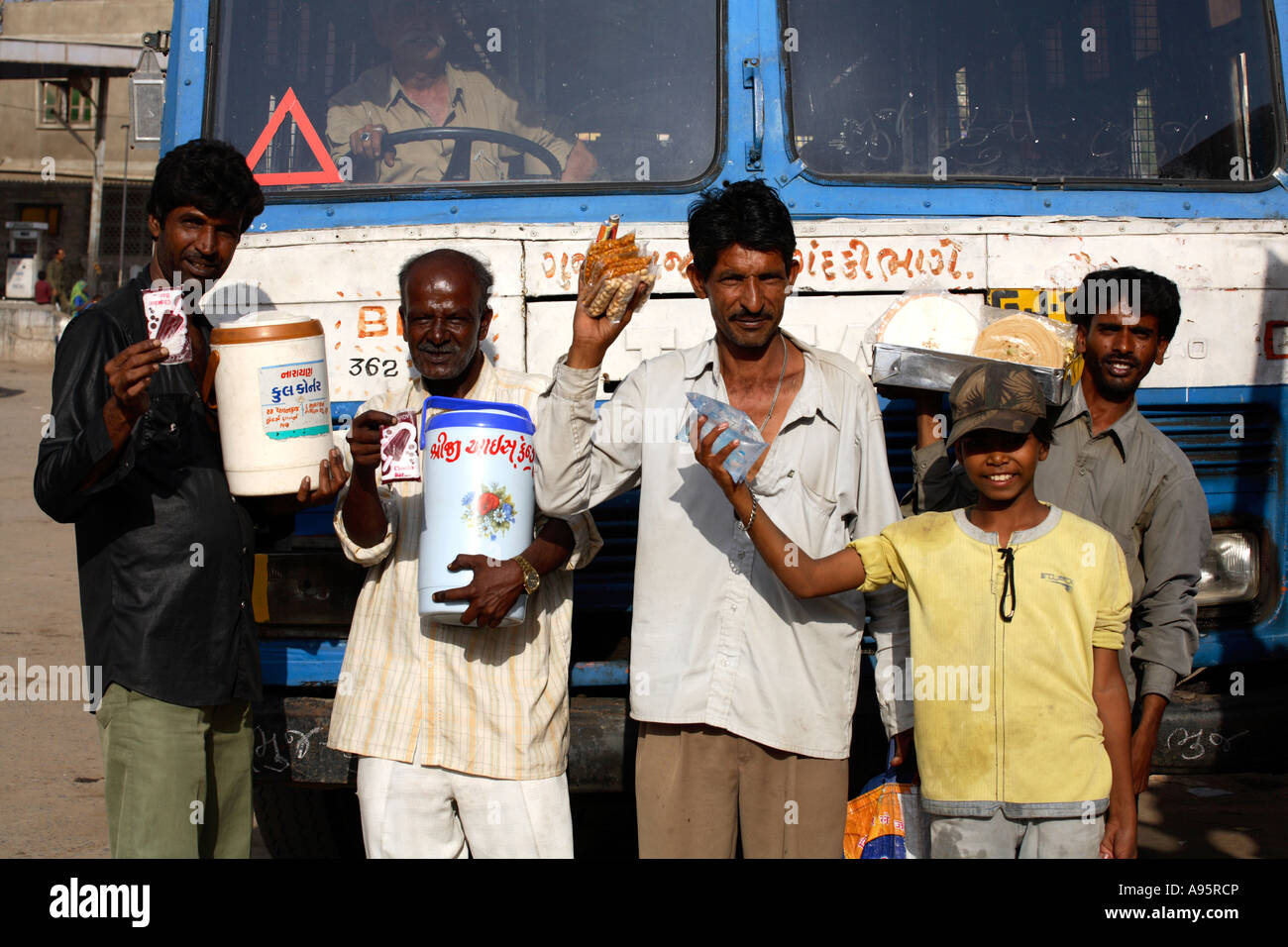 Male Indian hawkers holding up their goods at Bhuj Bus Stand, Gujarat ...