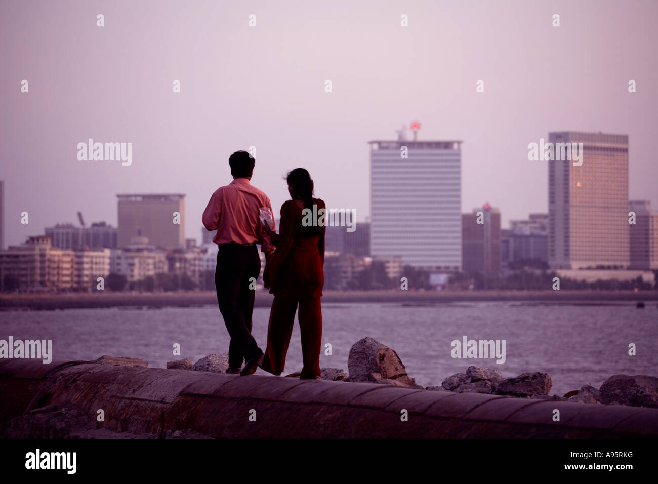 Indian Couple stroll along wall at sunset on Marine Drive, Mumbai ...
