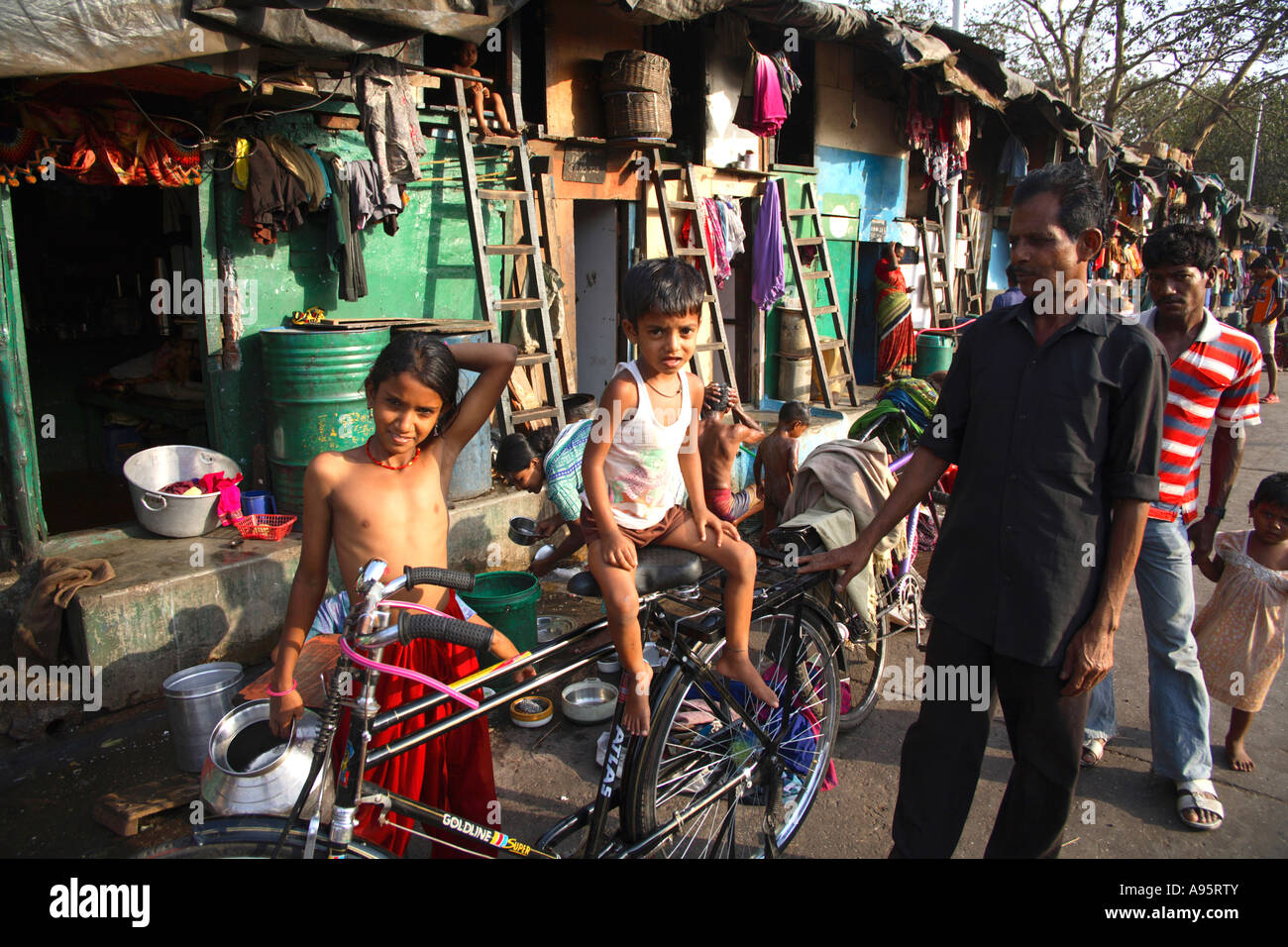Families outside permanent roadside home, D'Mello Road, Mumbai, India ...