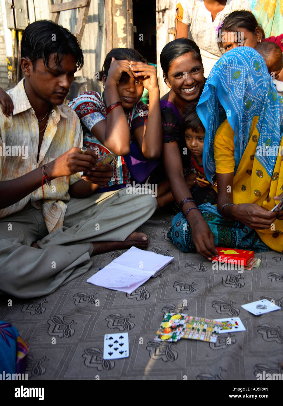 Indian family playing cards on street outside shanty home, D'Mello Road ...