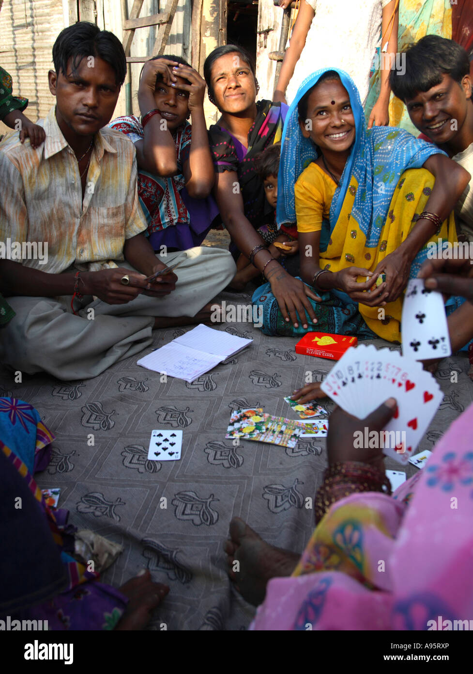 Indian family playing cards on street outside shanty home, D'Mello Road ...