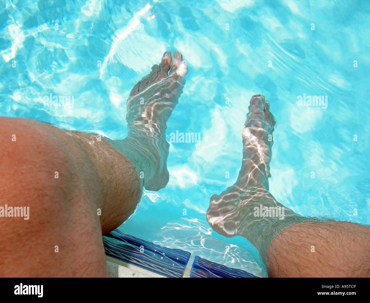 Feet dangling in swimming pool hi-res stock photography and images - Alamy