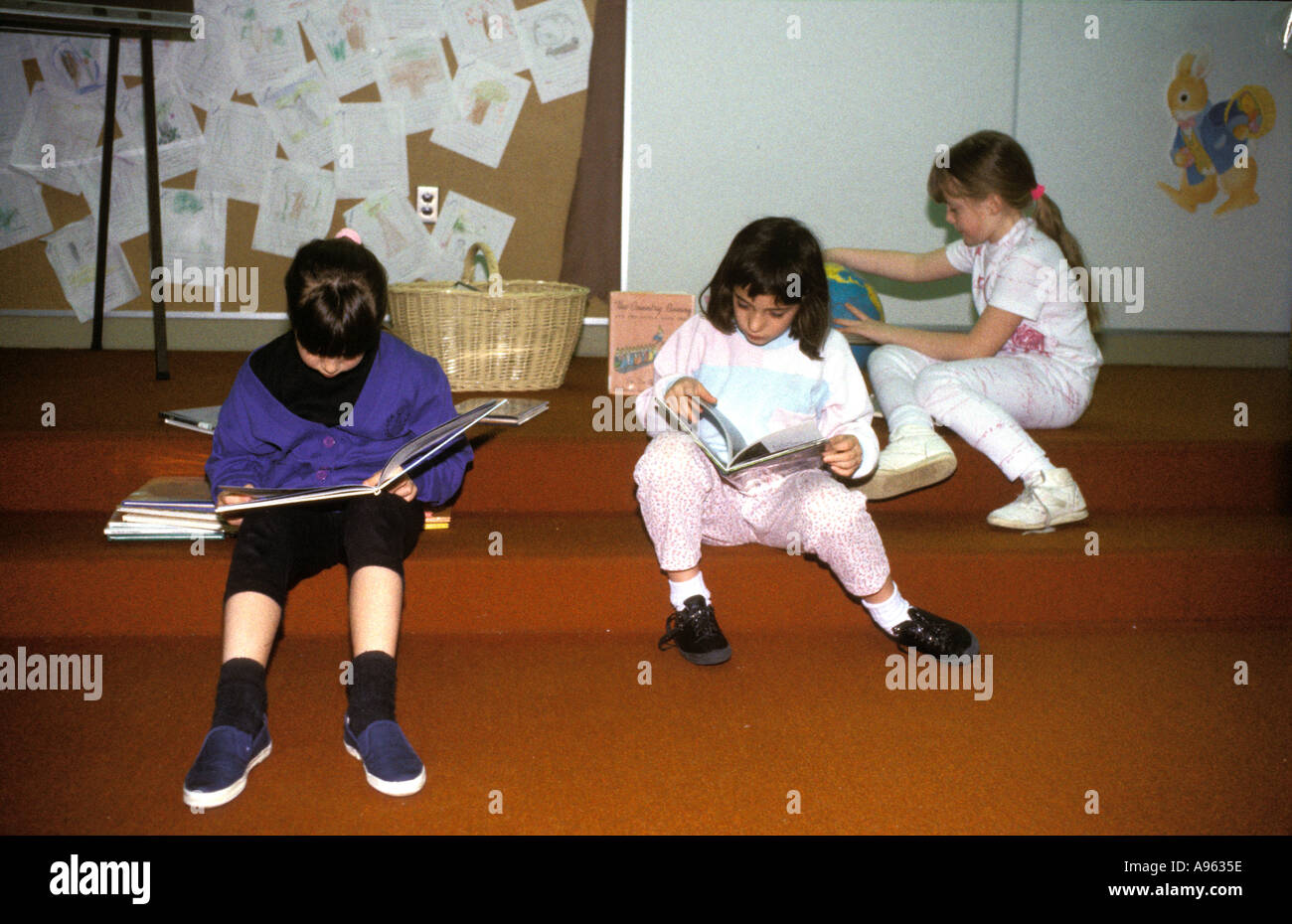 Primary school children readinGBooks in classroom Stock Photo - Alamy