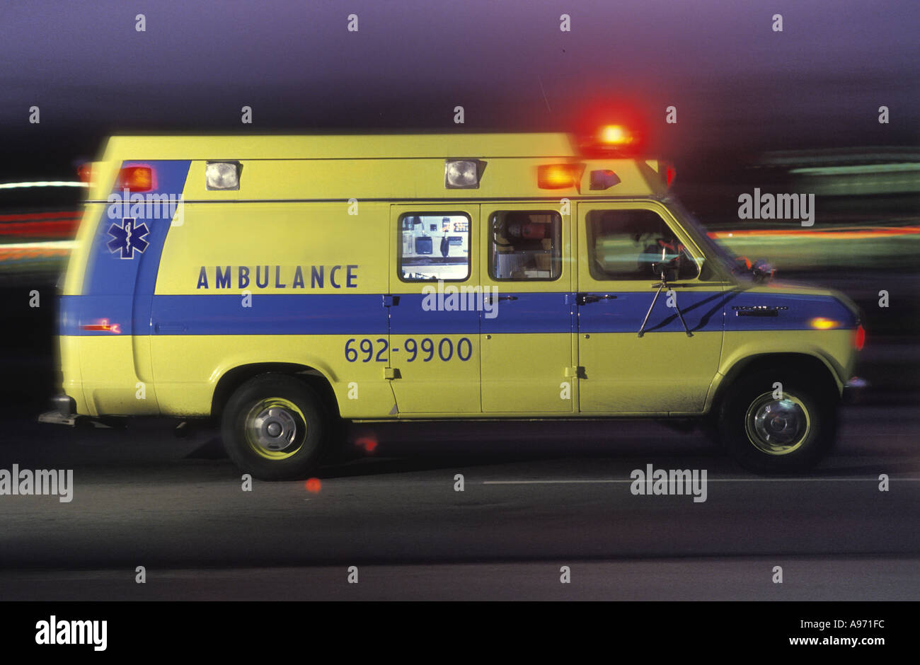 Ambulance rushing down road with lights on Stock Photo - Alamy