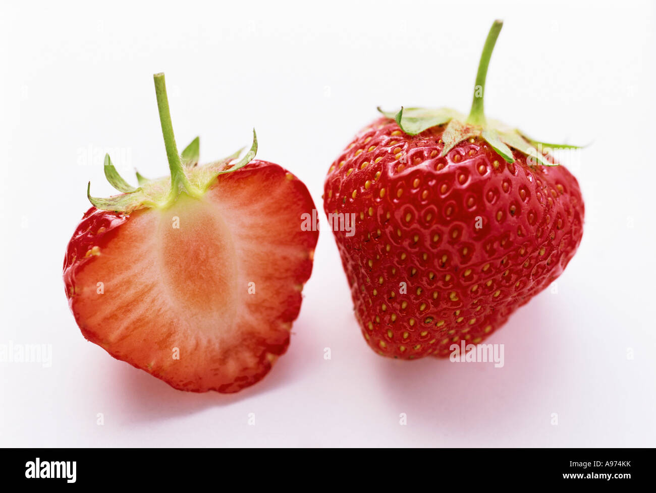 One whole and one halved strawberry hi-res stock photography and images ...
