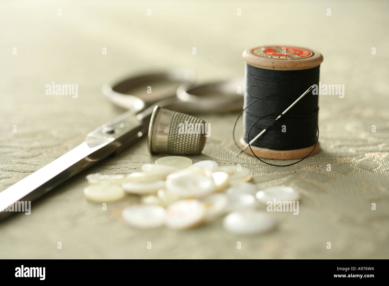 needle cotton scissors button on fabric cloth thimble Stock Photo - Alamy