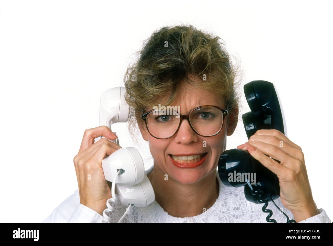 distraught female office worker holding four telephones Stock Photo - Alamy