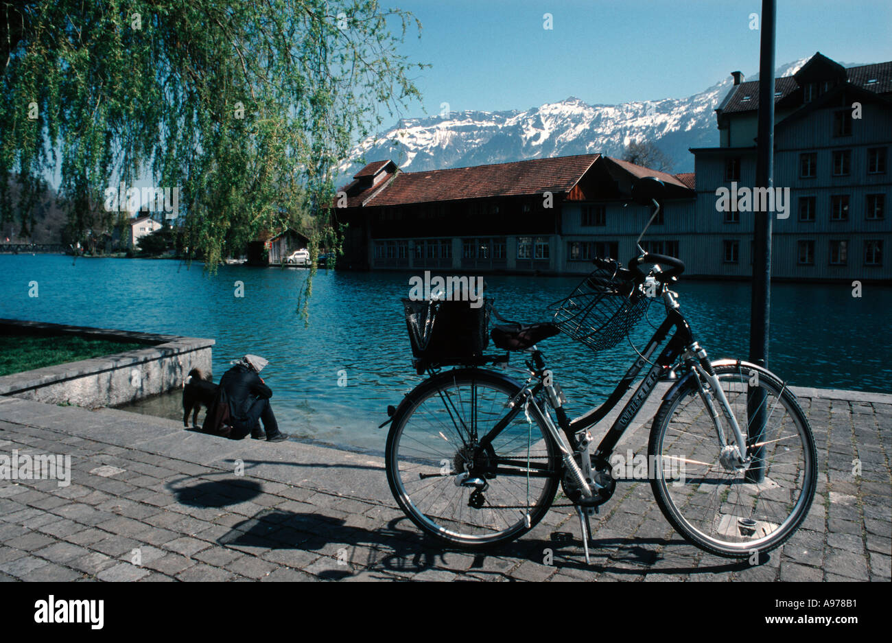Cyclist sitting at the edge of the river in Interlaken Switzerland with ...