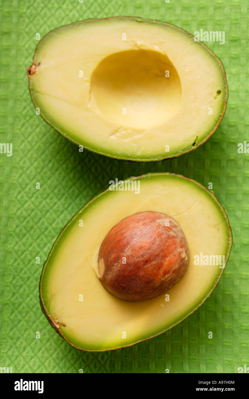 Avocado halved on green background FoodCollection Stock Photo - Alamy