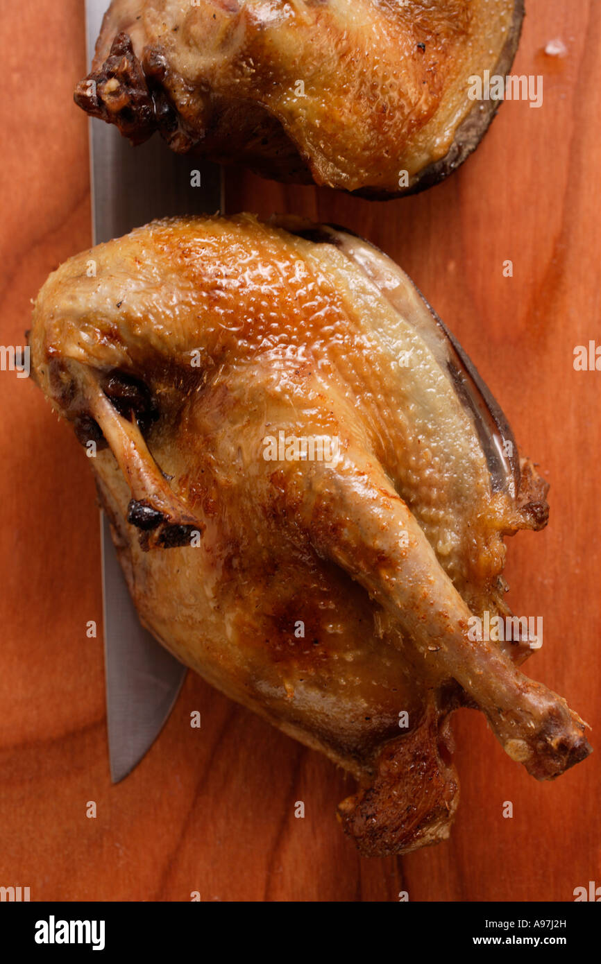 Roast pigeon halved on knife FoodCollection Stock Photo - Alamy