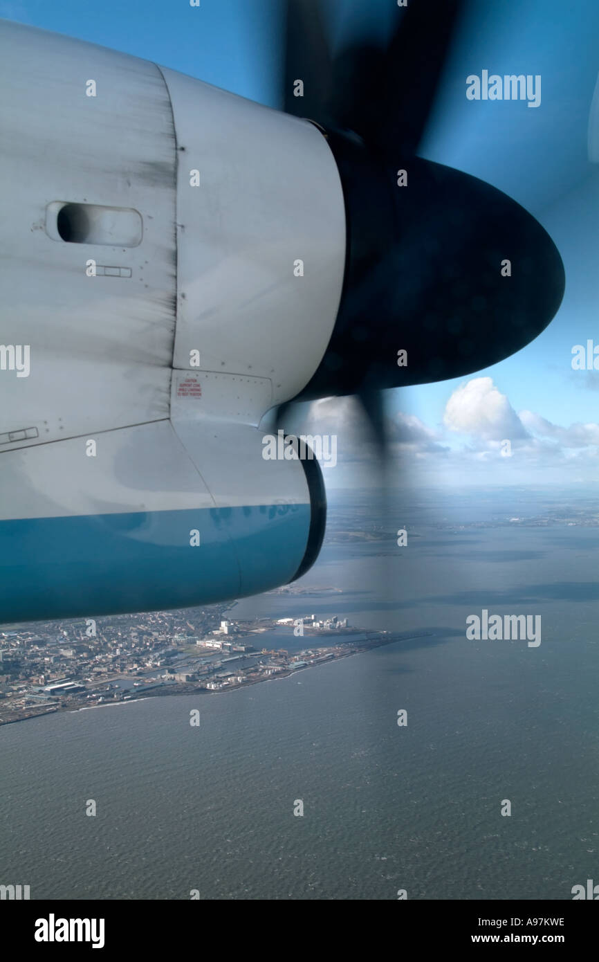 The engine and propeller of a small flybe airplane flies over Edinburgh ...
