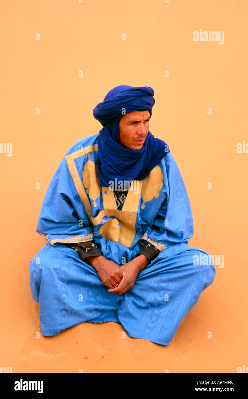 Berber male in traditional costume resting in the sands of the Sahara ...