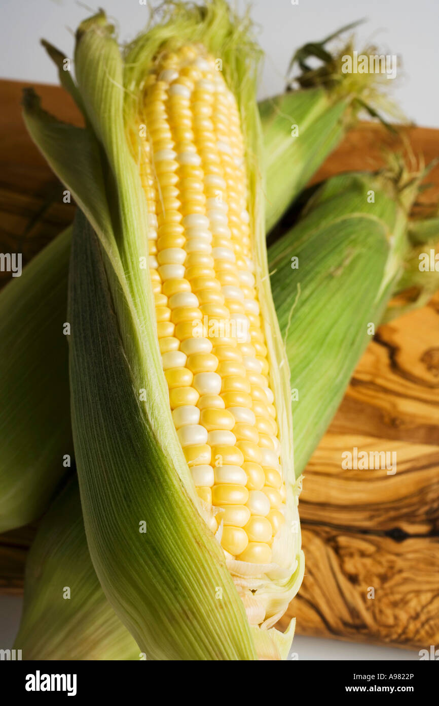 Three corn cobs with husks FoodCollection Stock Photo - Alamy
