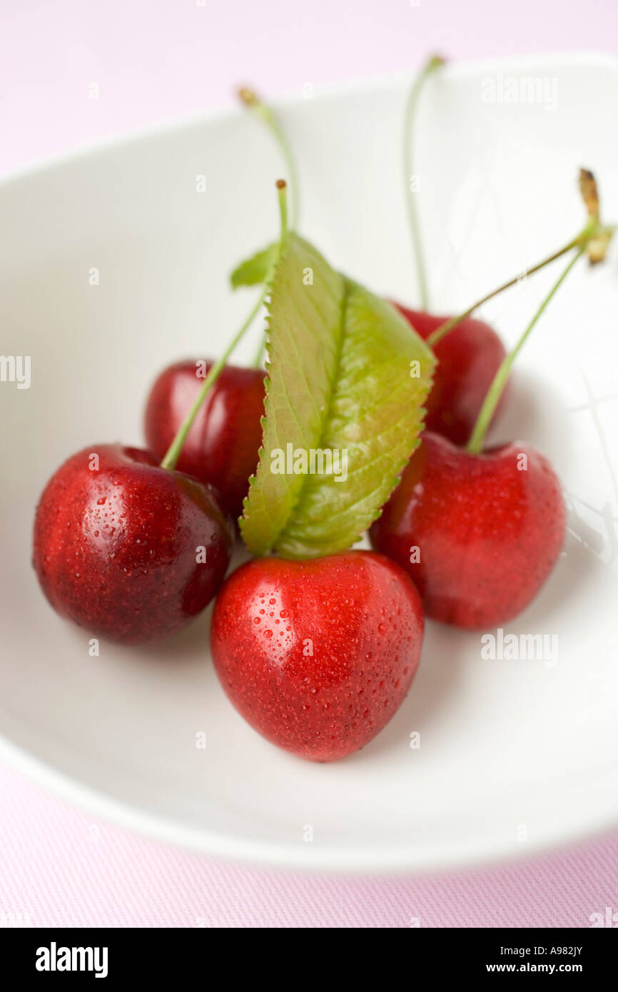 Five cherries with leaf in a small bowl FoodCollection Stock Photo - Alamy