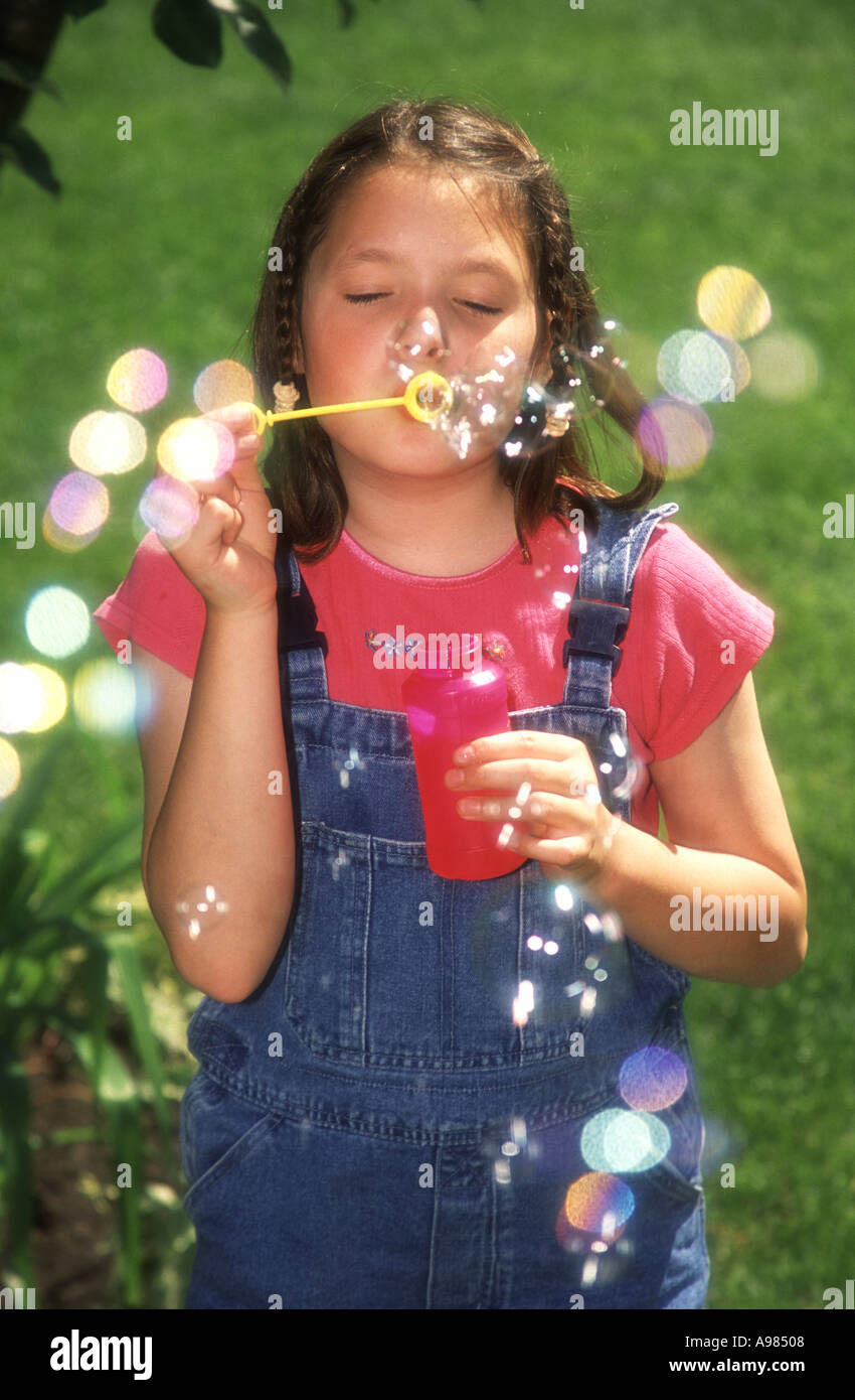 Eight year old girl blowing bubbles Stock Photo - Alamy