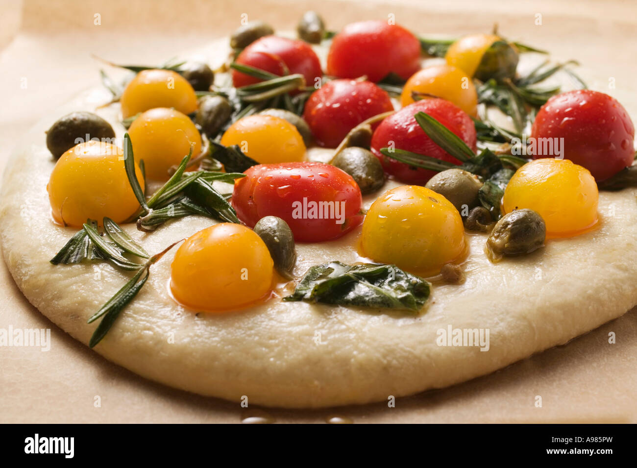 Unbaked pizza with cherry tomatoes capers rosemary FoodCollection Stock ...