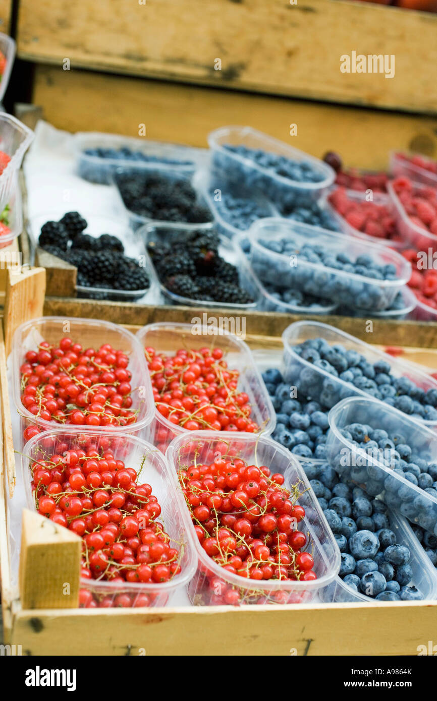 Various types of berries in plastic punnets at a market FoodCollection ...