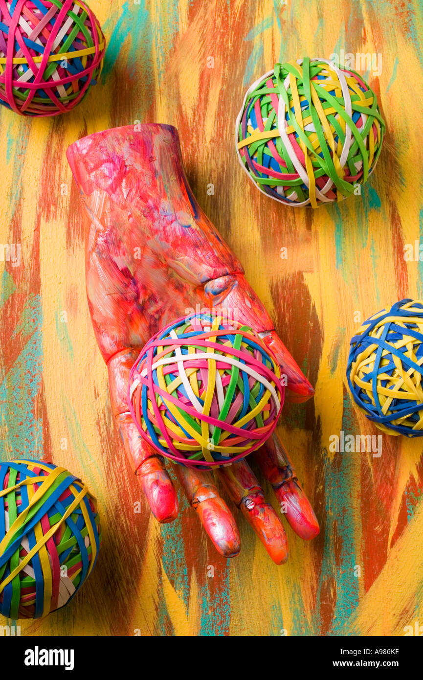 Wooden hand holding rubber band ball Stock Photo - Alamy