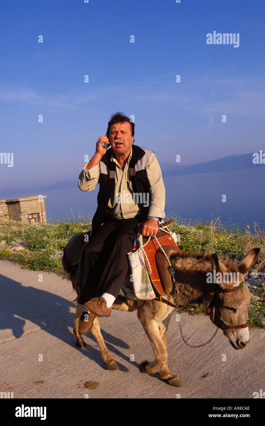 Greece, Hydra, Man on donkey with cell phone Stock Photo - Alamy