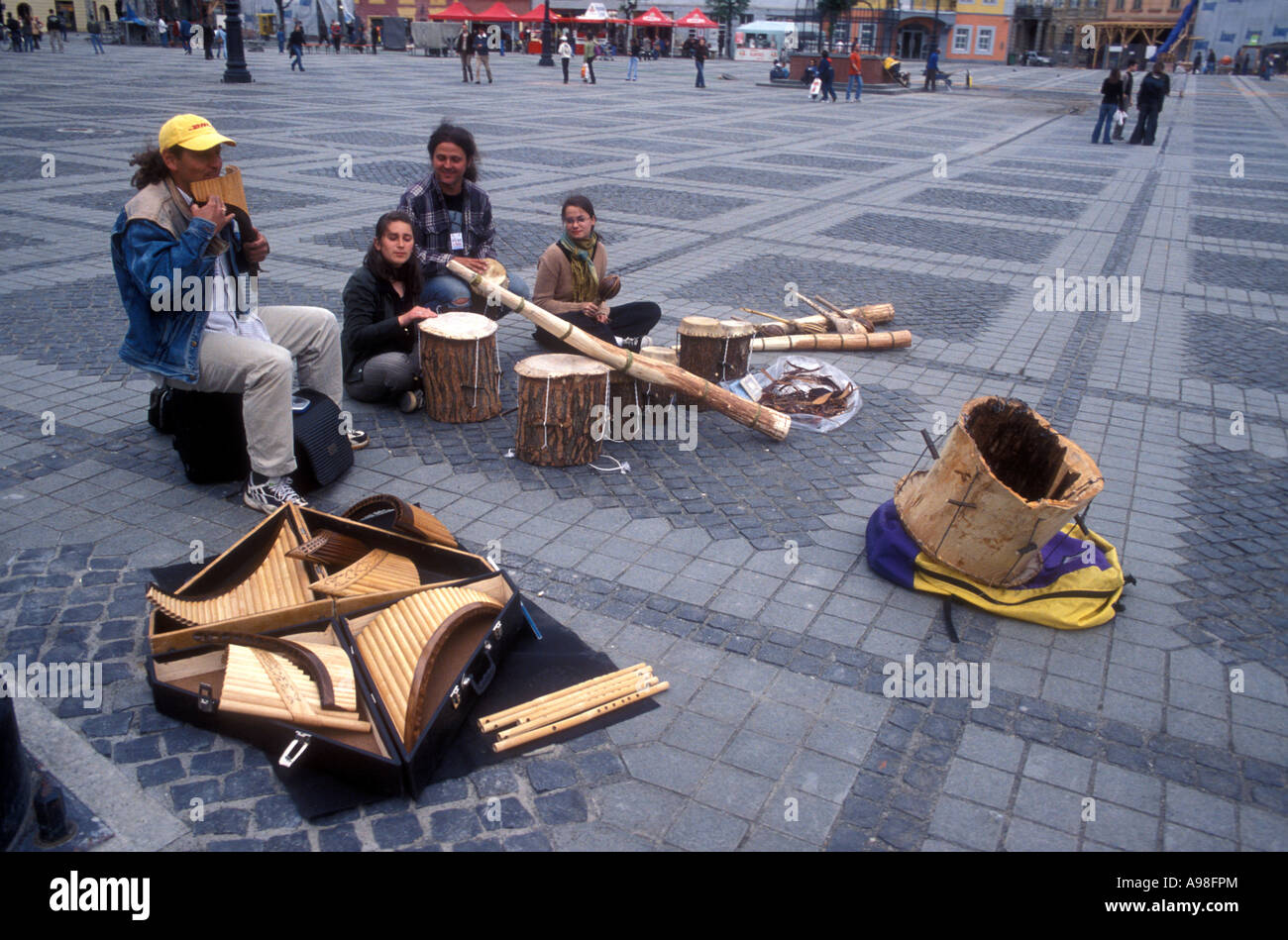 A quartet of young street musicians playing wooden instruments, some ...