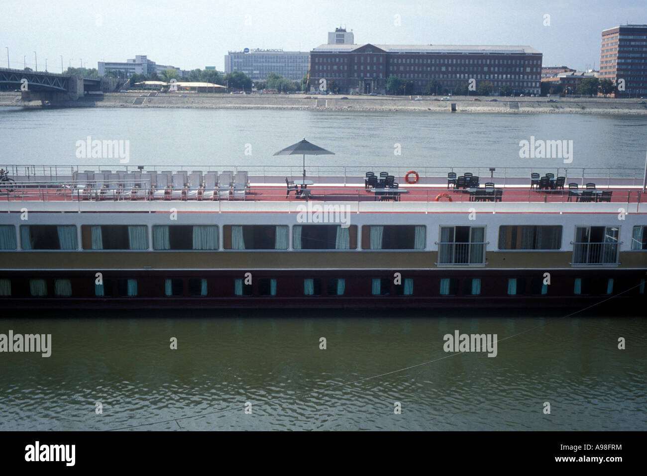 A very long Danube passenger ship docked at Budapest showing Buda in ...