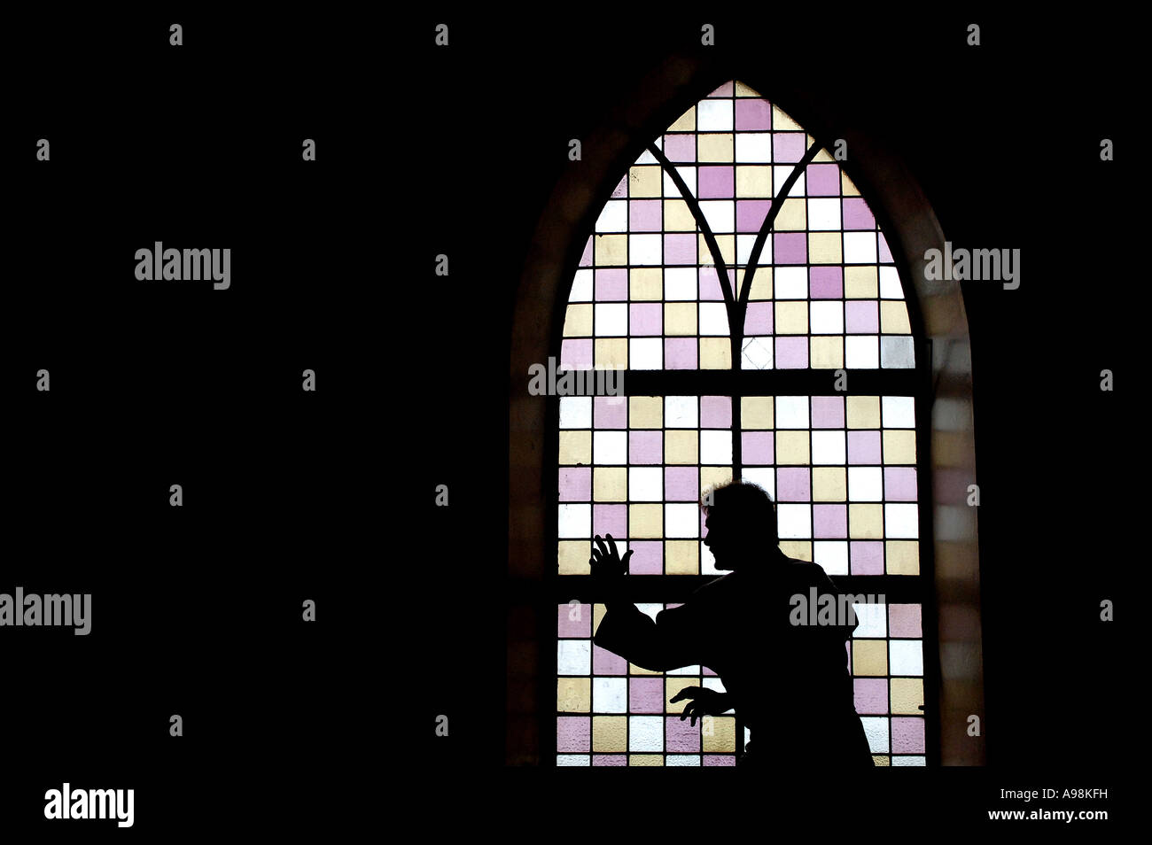 A judo teacher silhouetted against the light through a chapel window ...