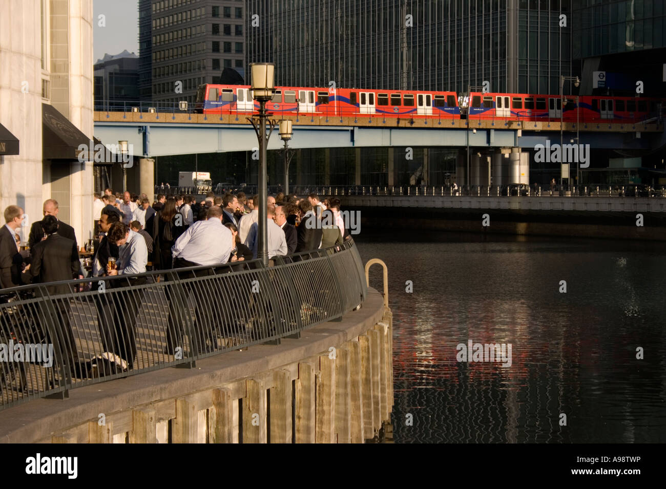 CANARY RIVERSIDE revellers, enjoying a drink after work, as a DLR train ...