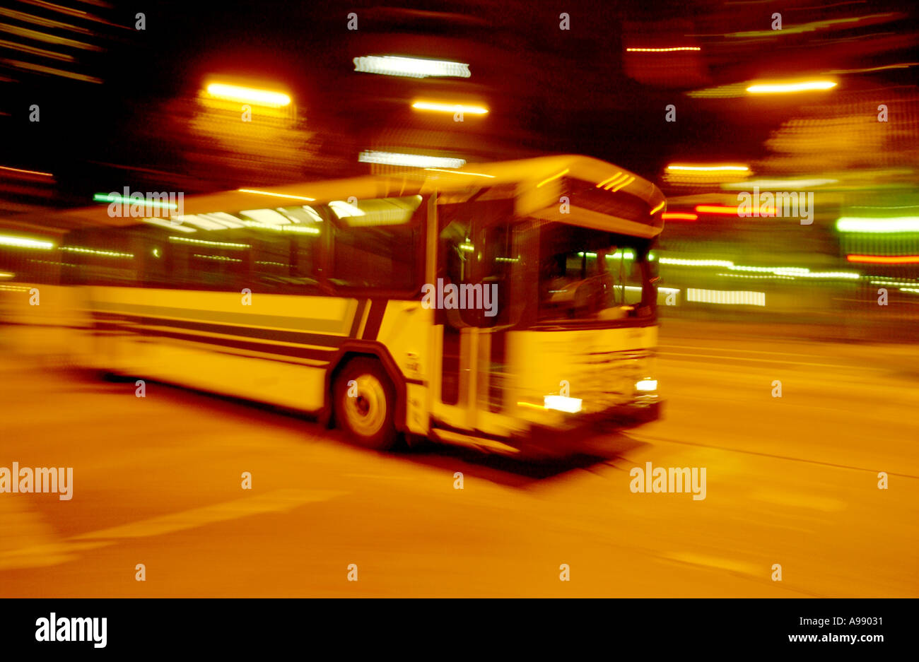 Horizontal color image of a city bus blurring past on a city street at ...
